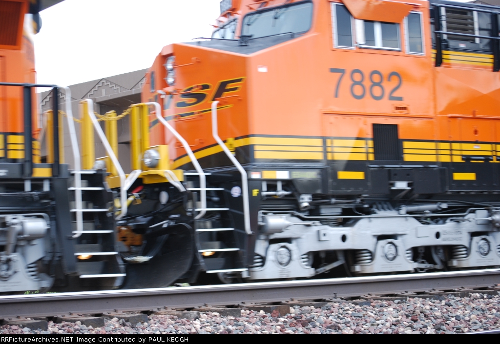 Close up shot of the cab of BNSF 7882 with the rear of BNSF 7883 (Lead Unit) as they roll past me.